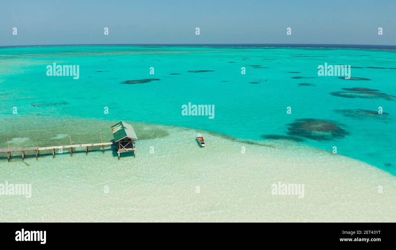 Tropical island in the ocean with palm trees on white sand beach. Onok ...