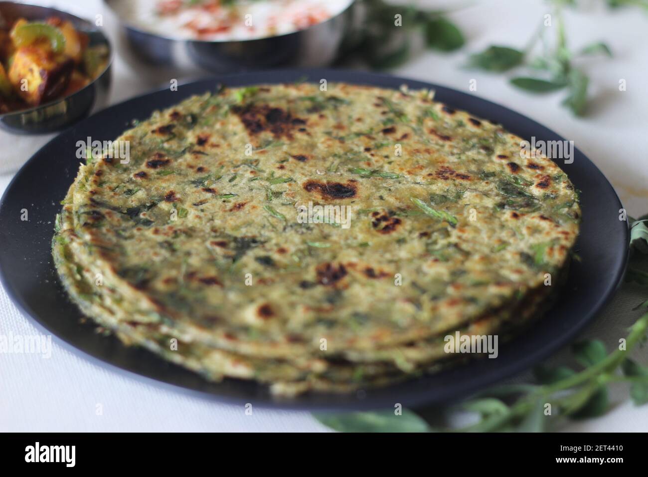 Whole wheat methi thepla rolls with paneer capsicum filling and a bowl ...