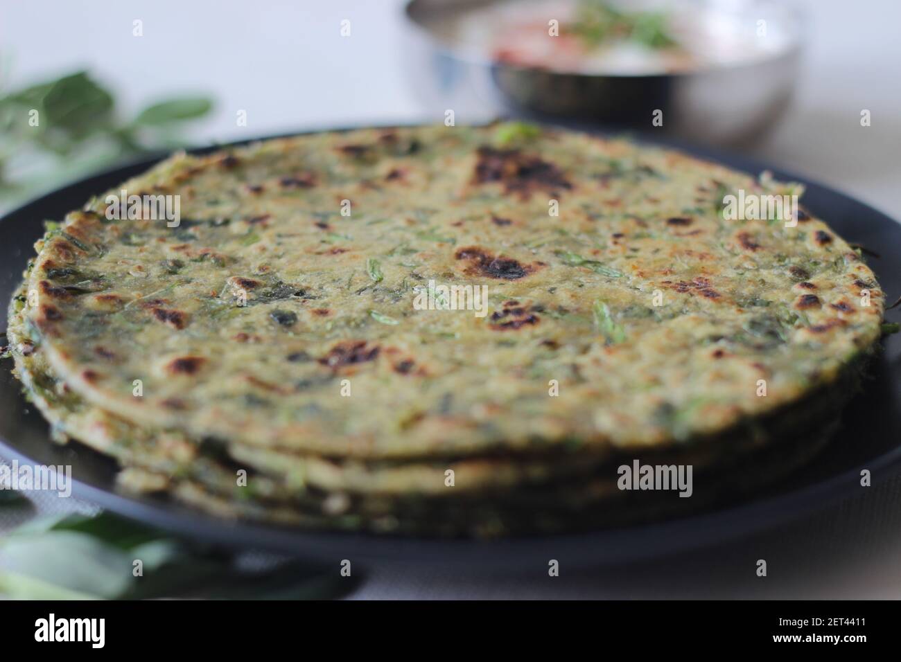 Whole wheat methi thepla rolls with paneer capsicum filling and a bowl ...