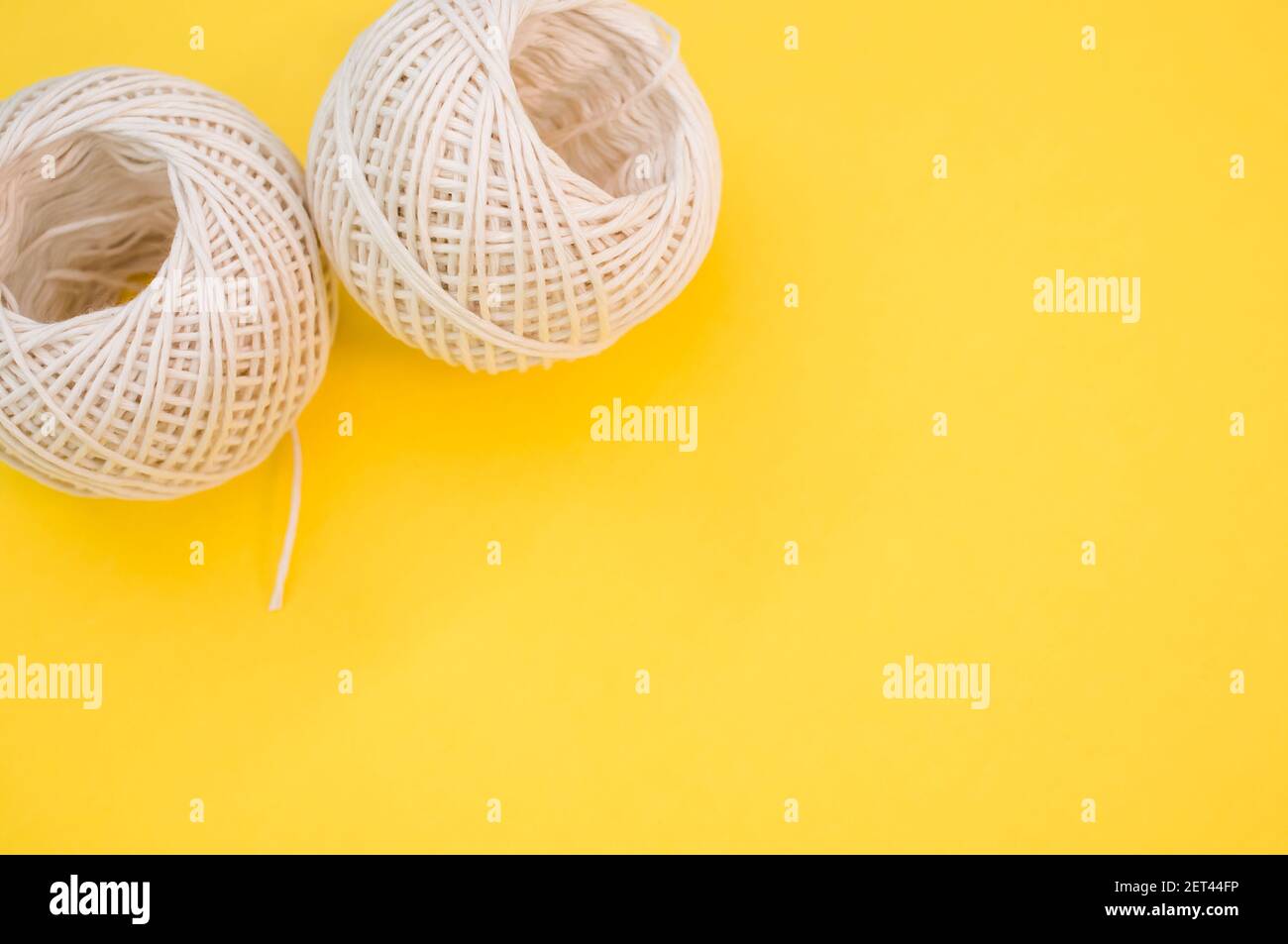 Two white balls of twine isolated on a yellow background Stock Photo ...