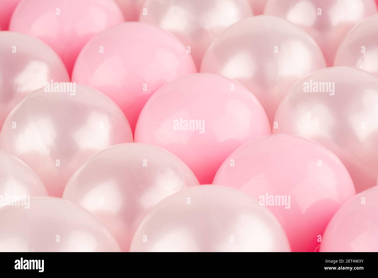 Pink and white plastic balls as a background Stock Photo - Alamy