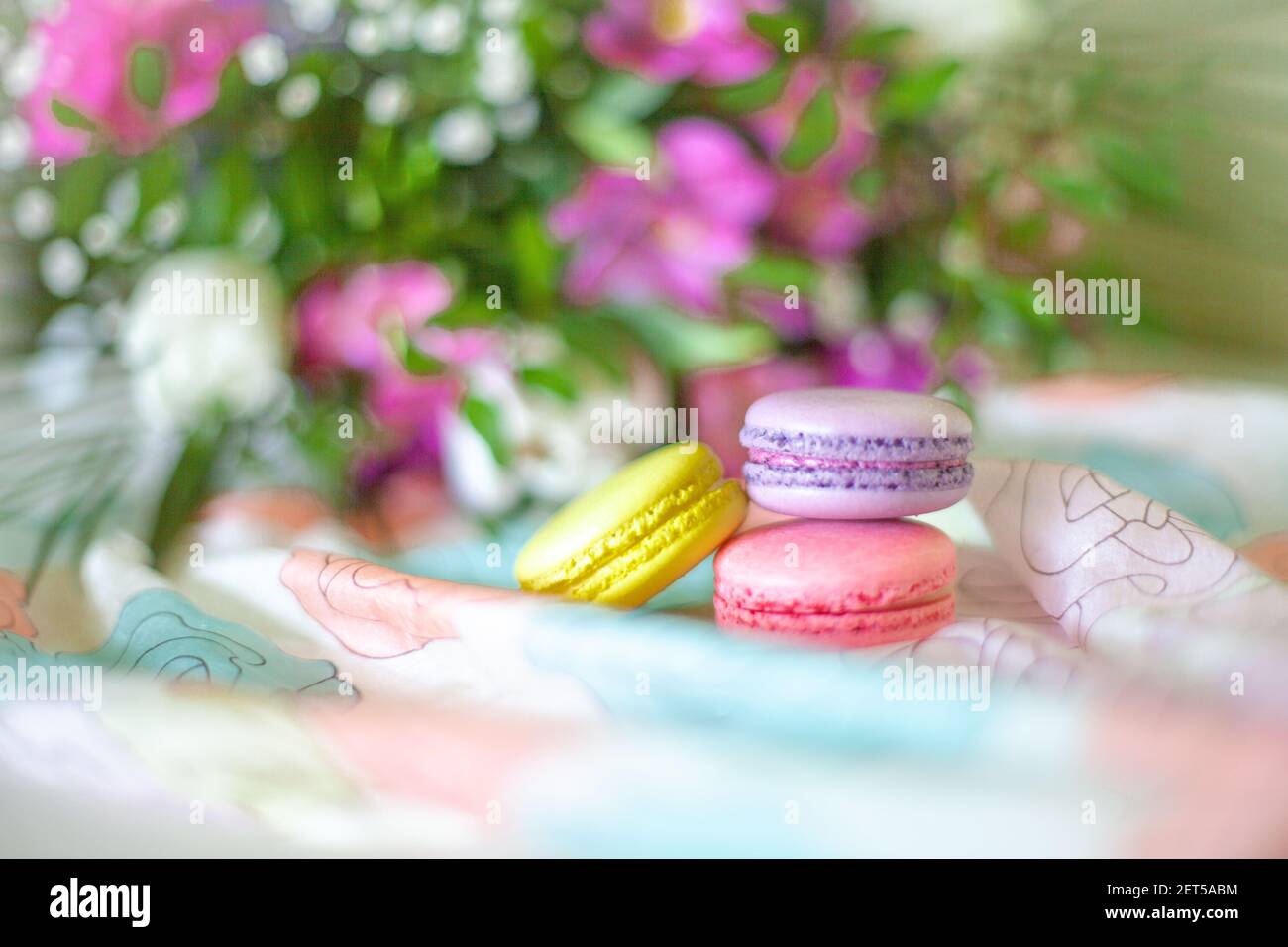 Colorful macarons decorated with spring flowers on bright background Stock Photo - Alamy