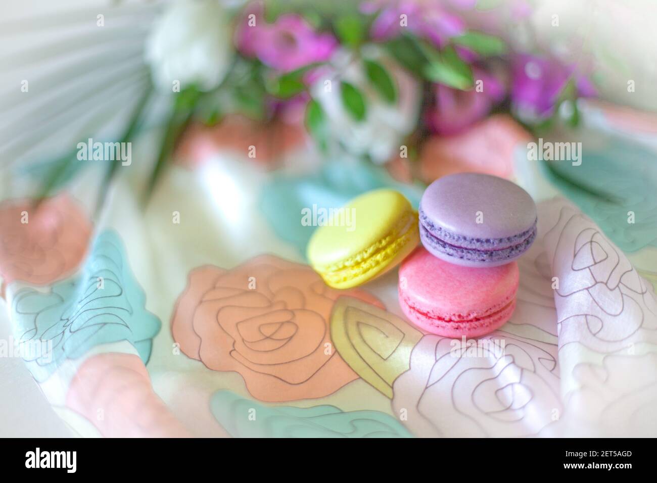 Colorful macarons decorated with spring flowers on bright background Stock Photo - Alamy
