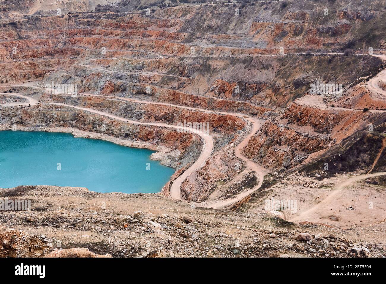 stepped slopes of an old limestone quarry with a blue lake at the ...