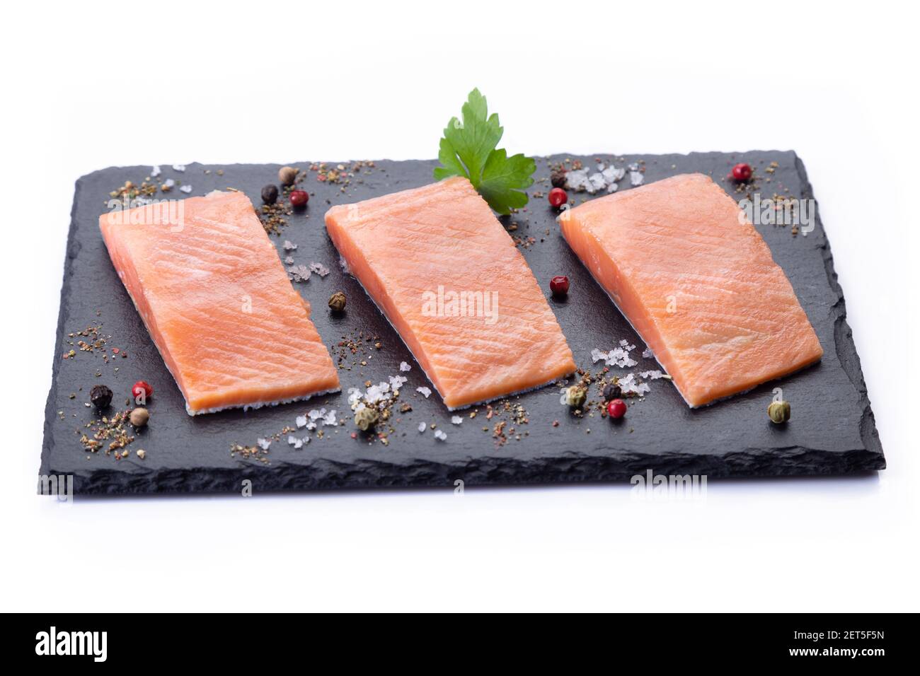 Three raw salmon filet on dark slate on white background Stock Photo ...