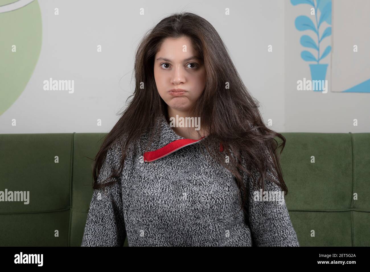 Photo of a sad young woman model sitting on the sofa Stock Photo - Alamy