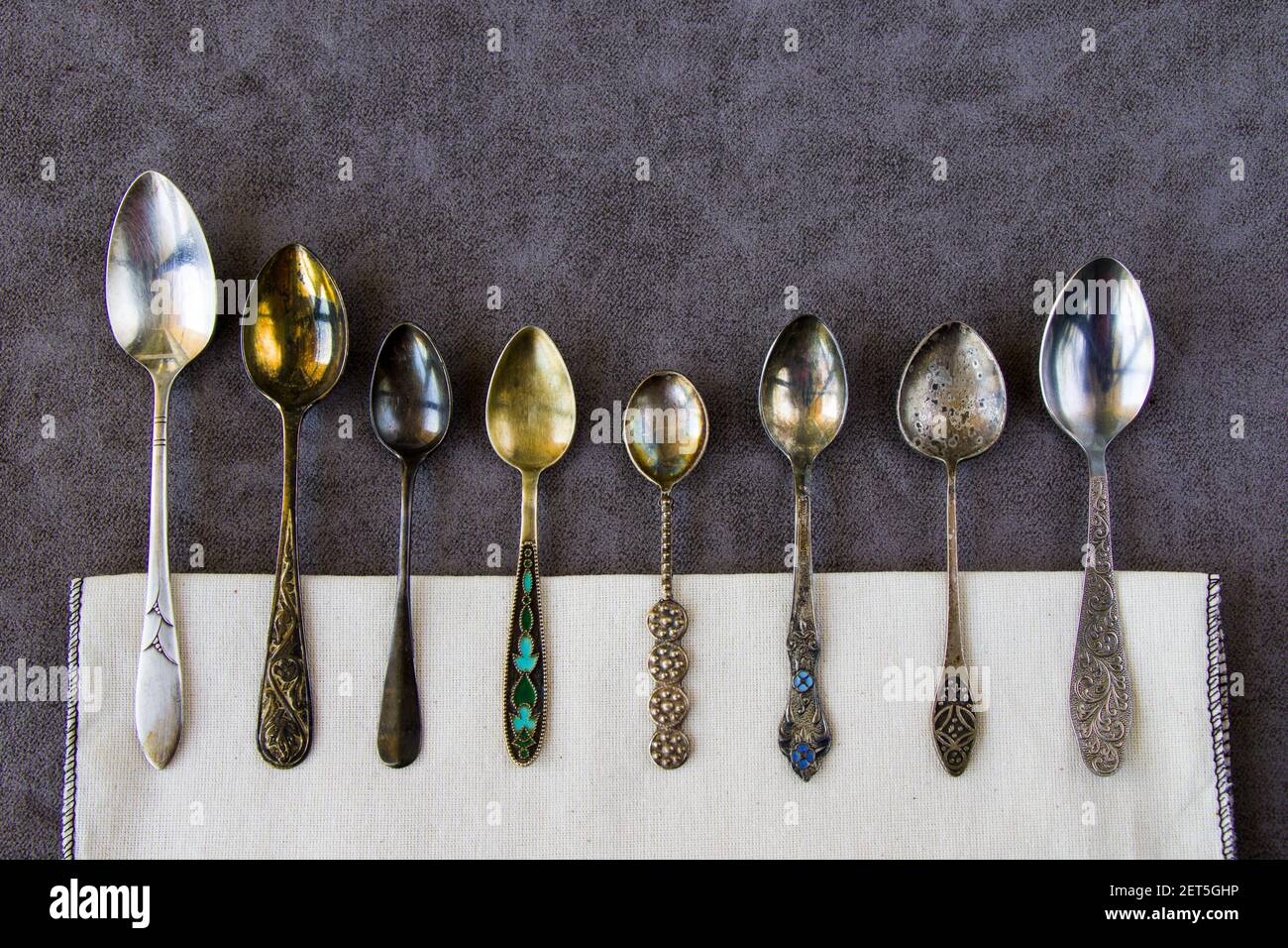 A vintage and retro spoons set, collection of silverware spoons on the gray and white background ...