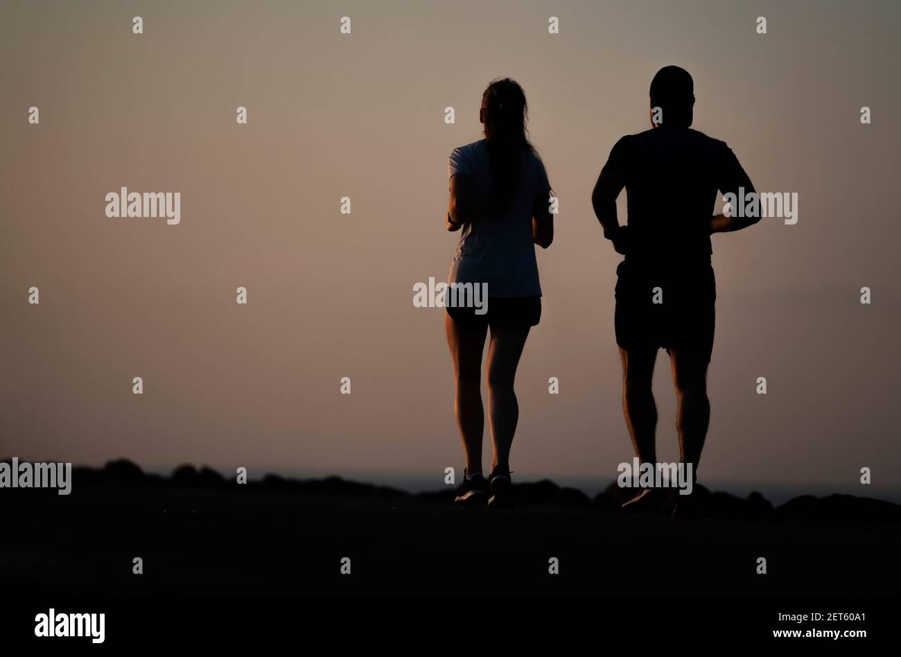 Silhouette of young man and woman running during sunset Stock Photo - Alamy