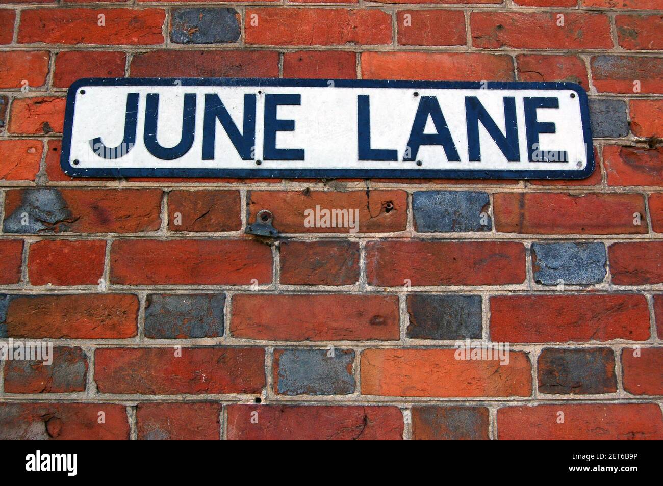 Road sign for the street June Lane fixed to a brick wall Stock Photo ...