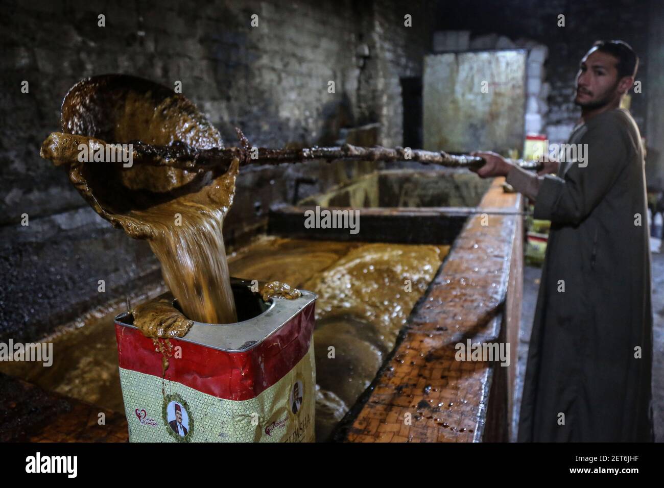Mallawi, Egypt. 01st Mar, 2021. A worker stirs sugarcane molasses ...