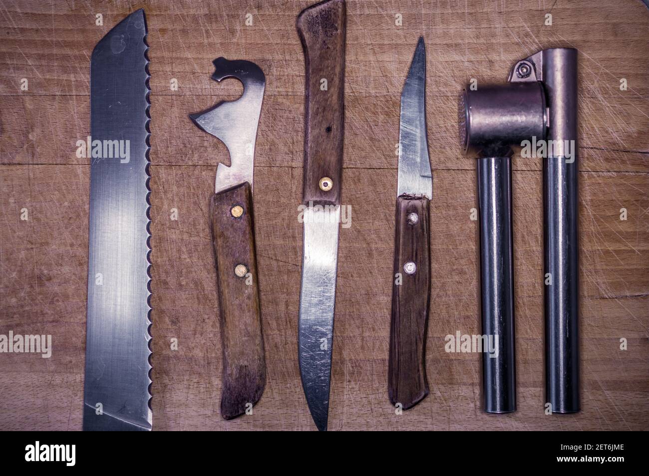 A top view of a set of kitchen knives with wooden handles and a garlic ...