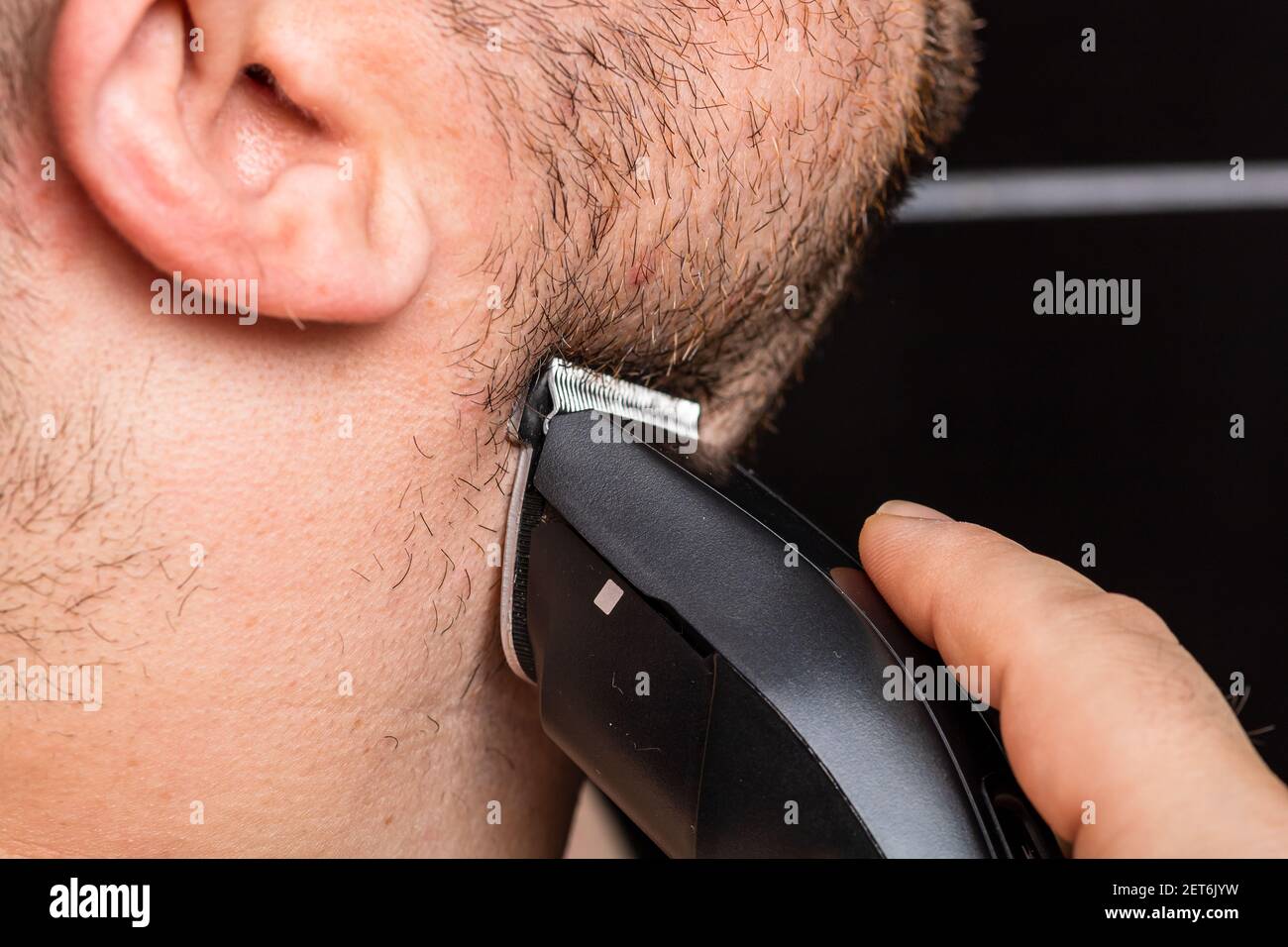Man shaving or trimming his beard using a hair clipper Stock Photo - Alamy