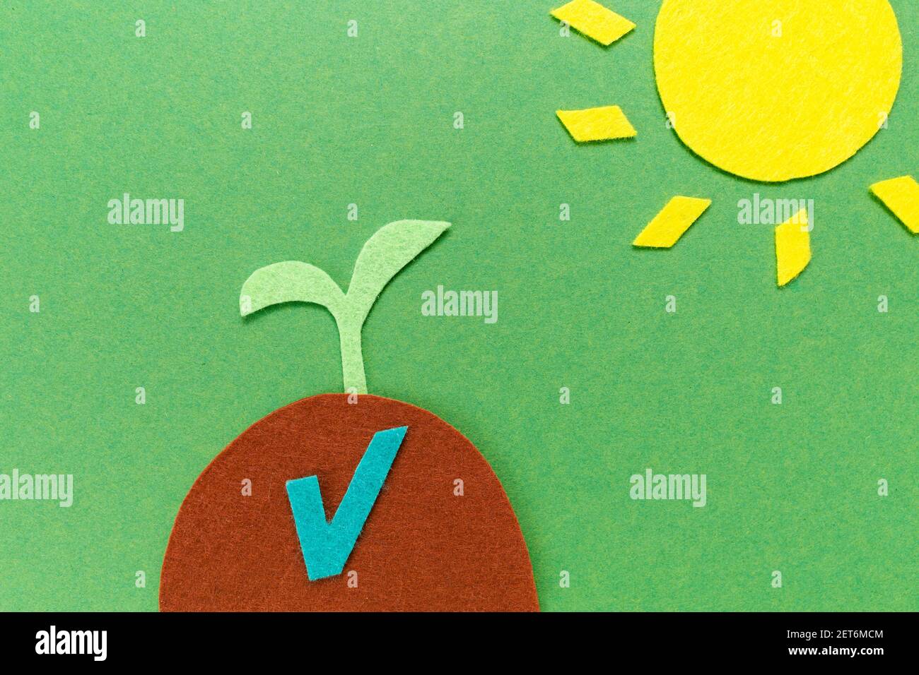 Cutted out of felt a soil with a plant sprout and sun. Graen background ...