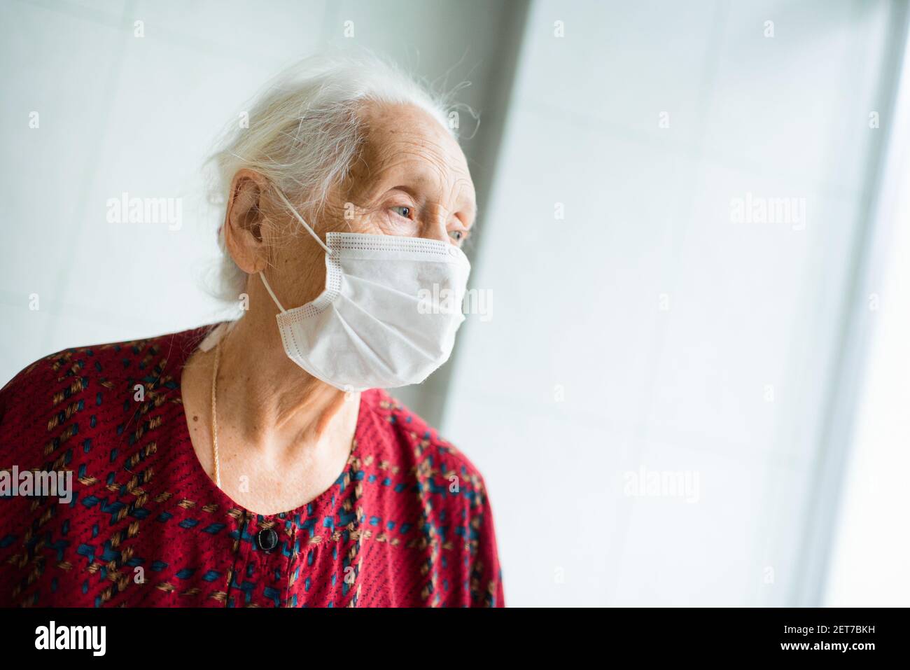 elderly woman of 70-80 years old with gray hair and sad eyes in a ...