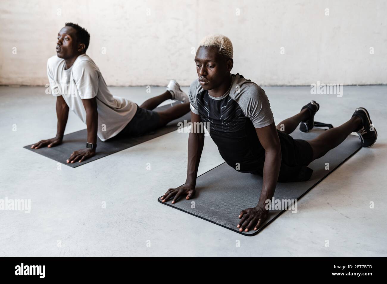 Two young athletic african american men doing workout on exercise mat ...