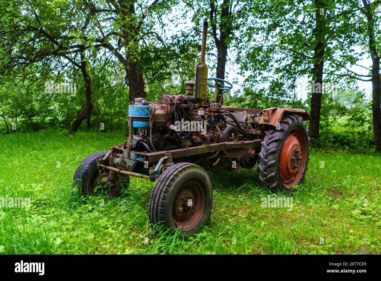 old broken tractor in the field with rust and missing parts Stock Photo ...