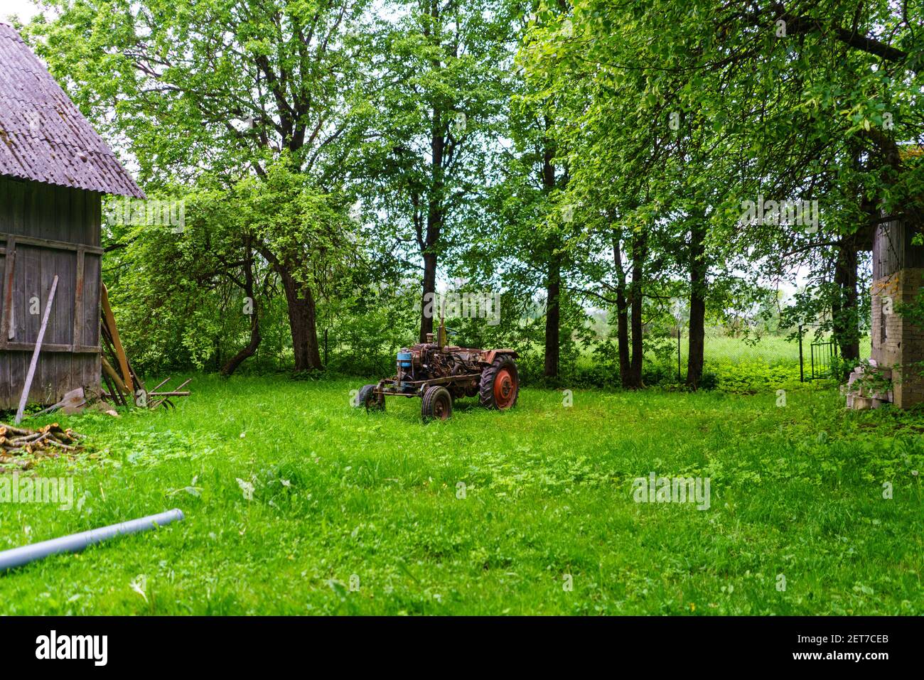 old broken tractor in the field with rust and missing parts Stock Photo ...