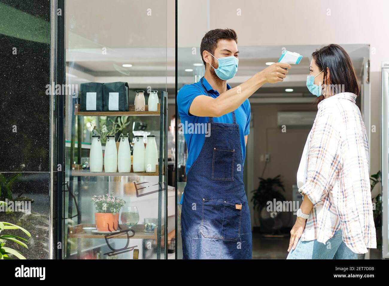 Checking body temperature of customer Stock Photo - Alamy