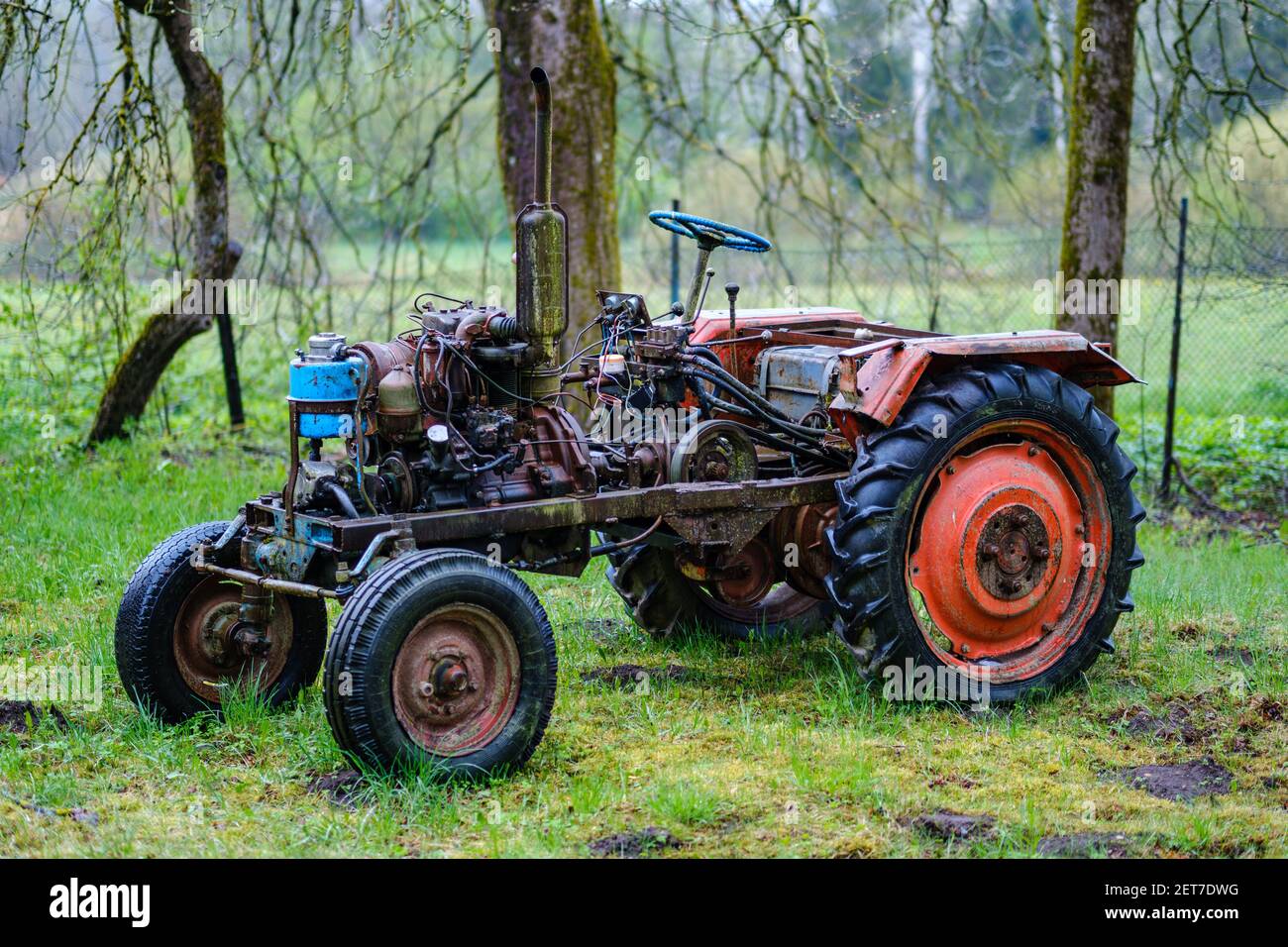 old broken tractor in the field with rust and missing parts Stock Photo ...