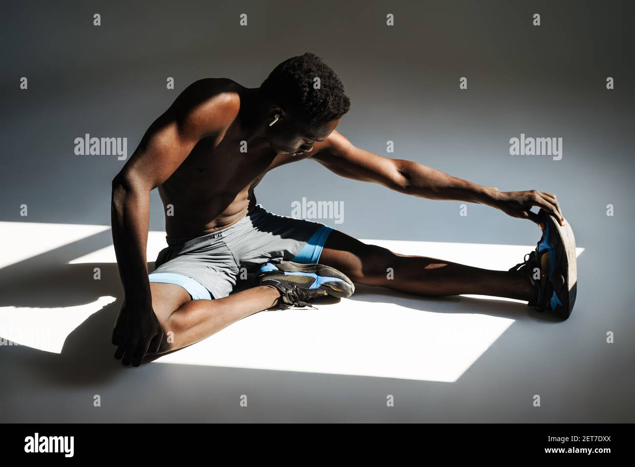 Confident young african sportsman exercising on a fitness mat isolated ...