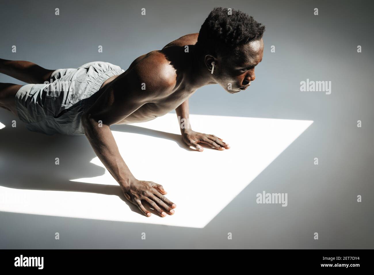 Confident young african sportsman exercising on a fitness mat isolated ...