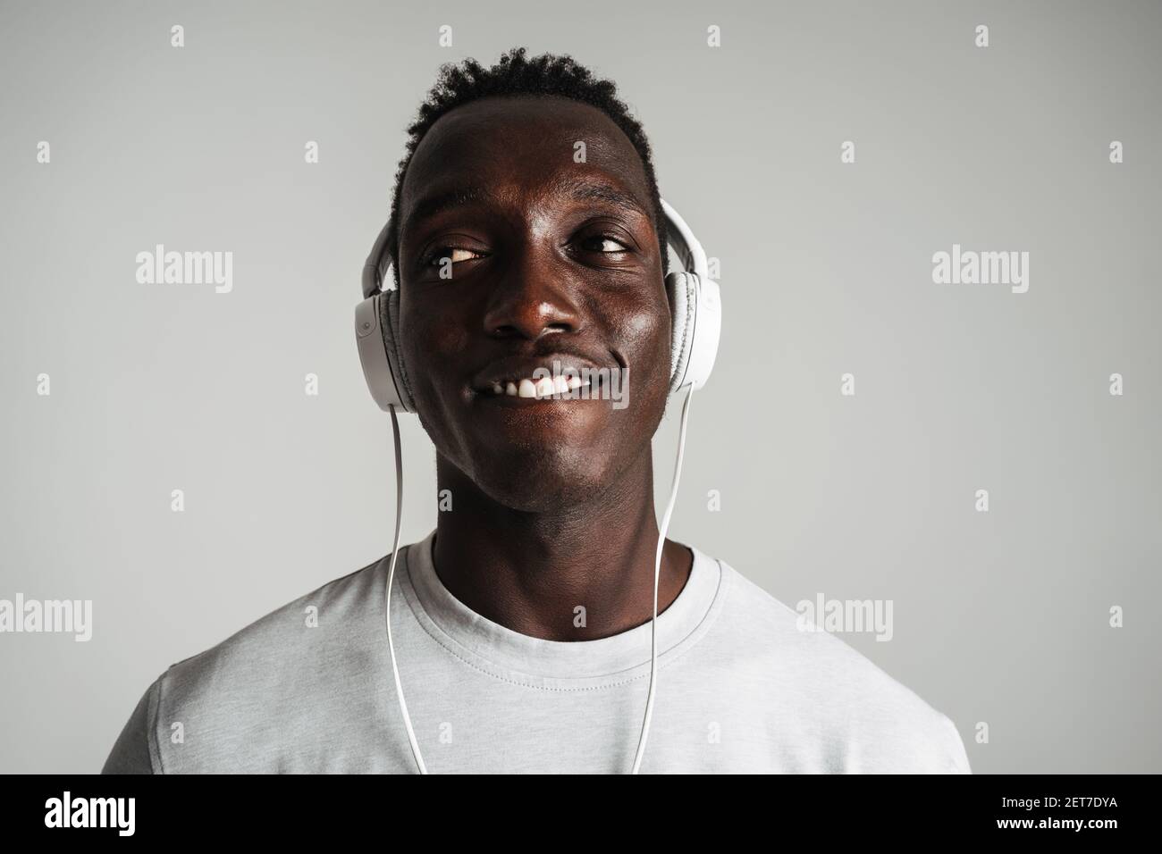 Happy young african man wearing casual outfit listening to music with ...
