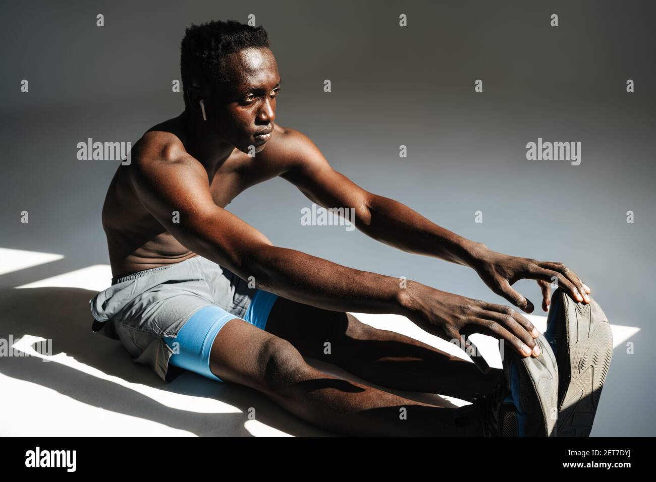 Confident young african sportsman exercising on a fitness mat isolated ...
