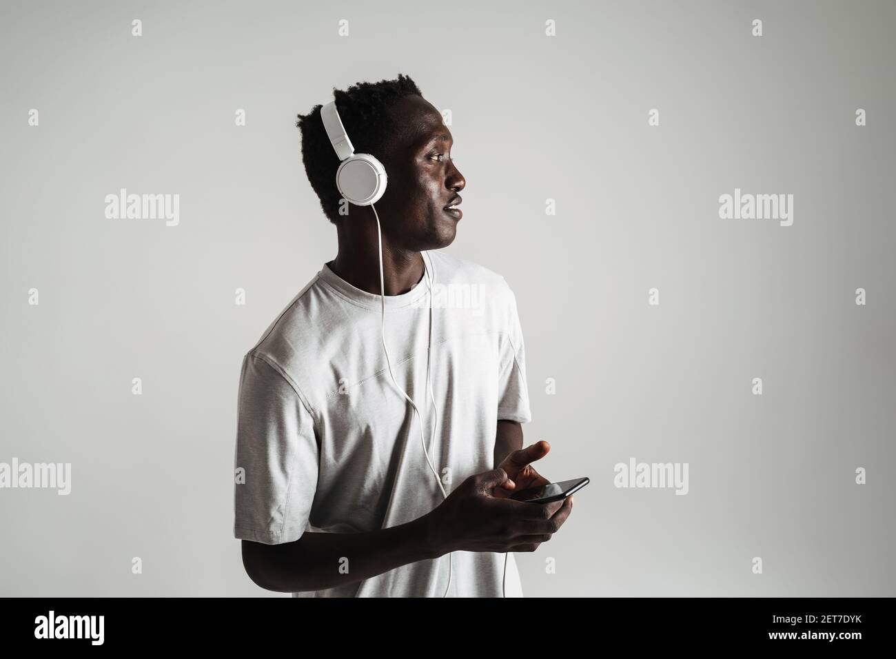 Young african man wearing casual outfit listening to music with ...