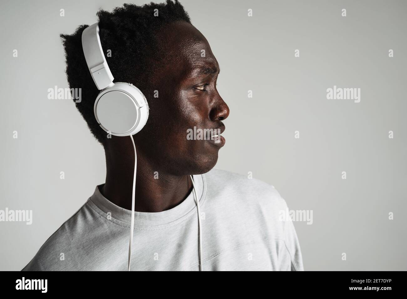 Young african man wearing casual outfit listening to music with ...