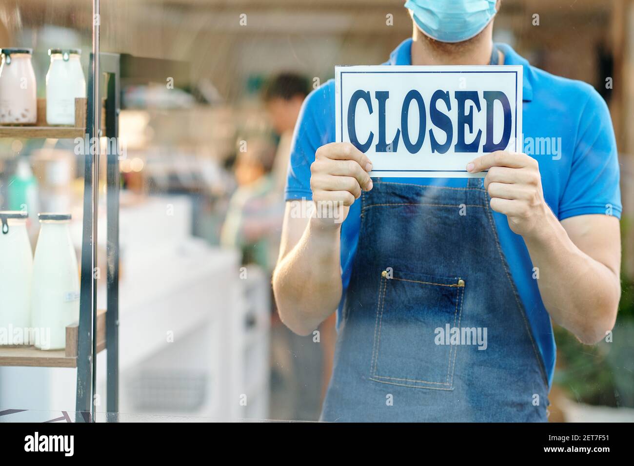 Waiter showing closed sign Stock Photo - Alamy