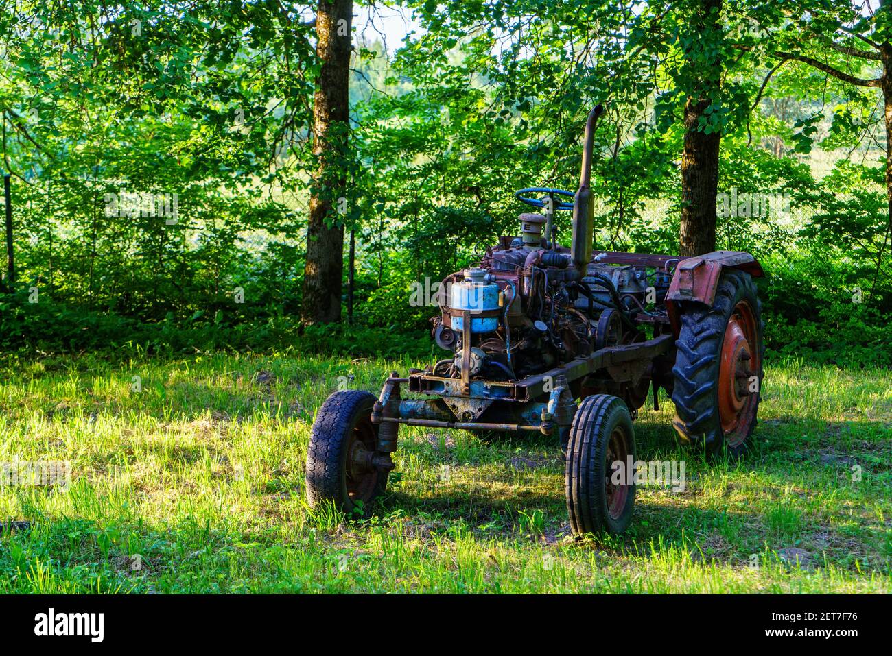 old broken tractor in the field with rust and missing parts Stock Photo ...