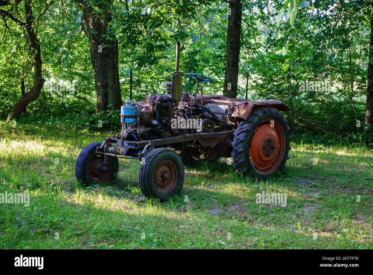 old broken tractor in the field with rust and missing parts Stock Photo ...