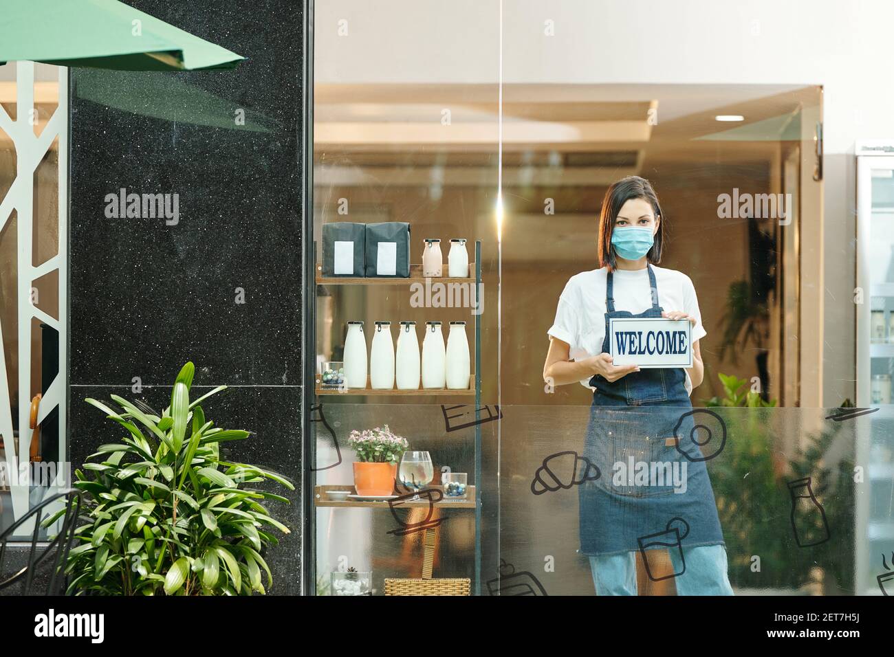 Store owner with welcome sign Stock Photo - Alamy