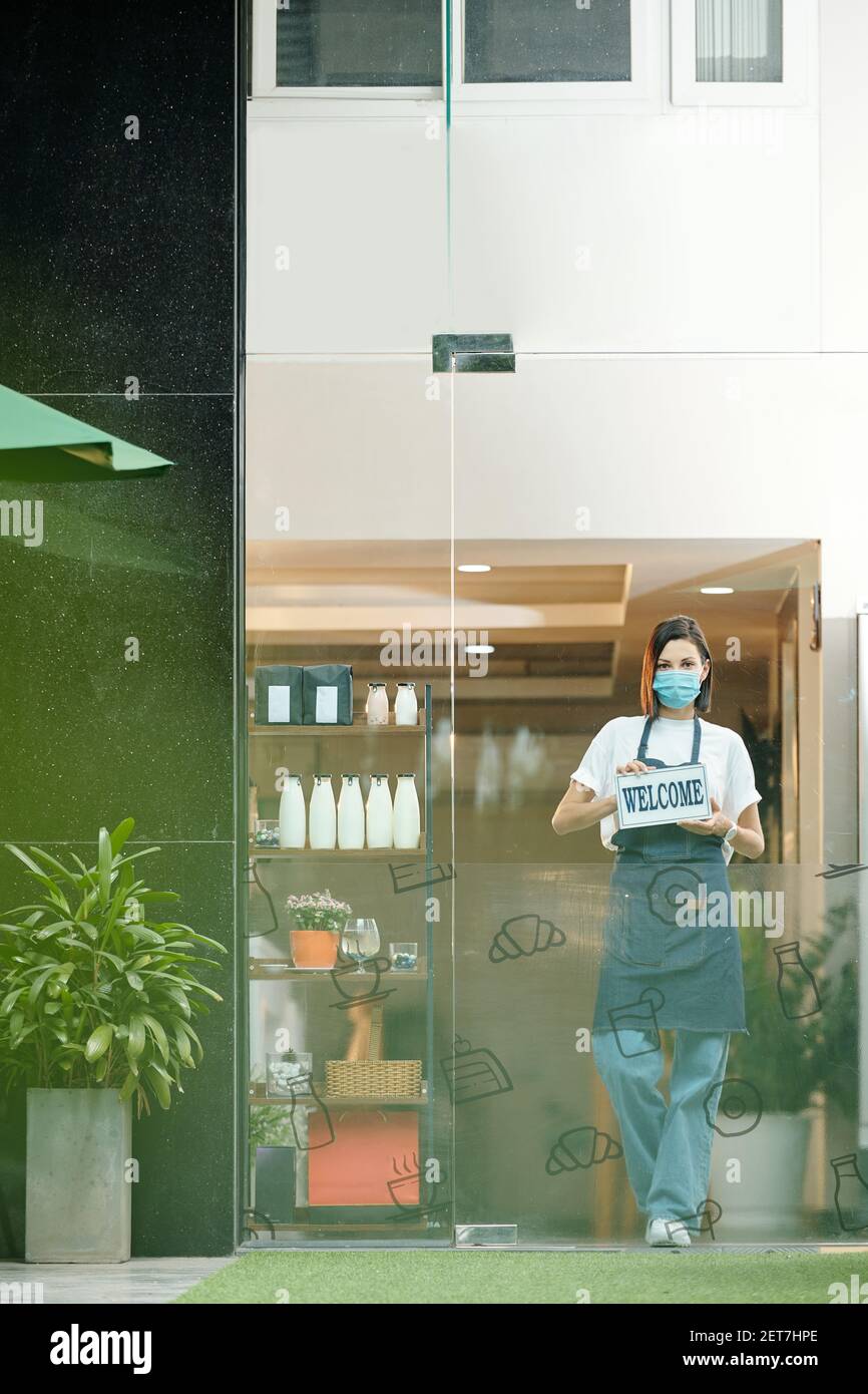 Woman welcoming clients in store Stock Photo - Alamy
