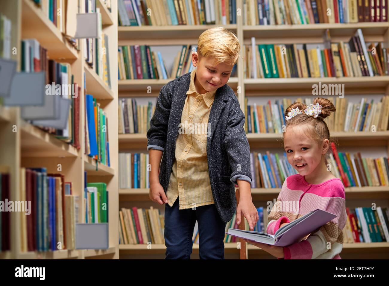 boy and girl discussing book in school library, people lifestyles and ...