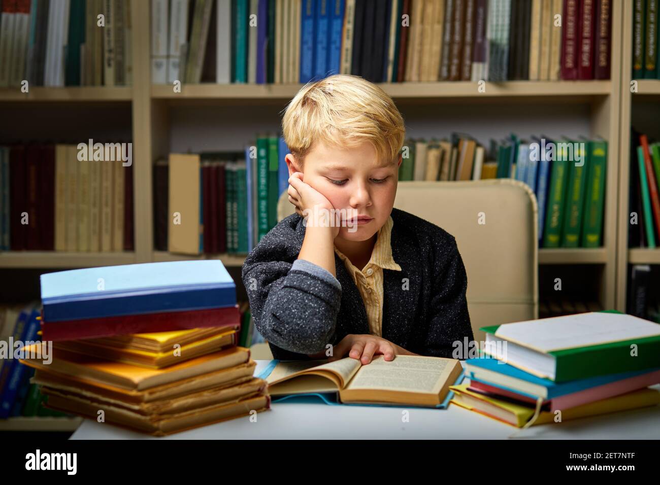 sleepy little boy tired of learning doing homework reading book ...