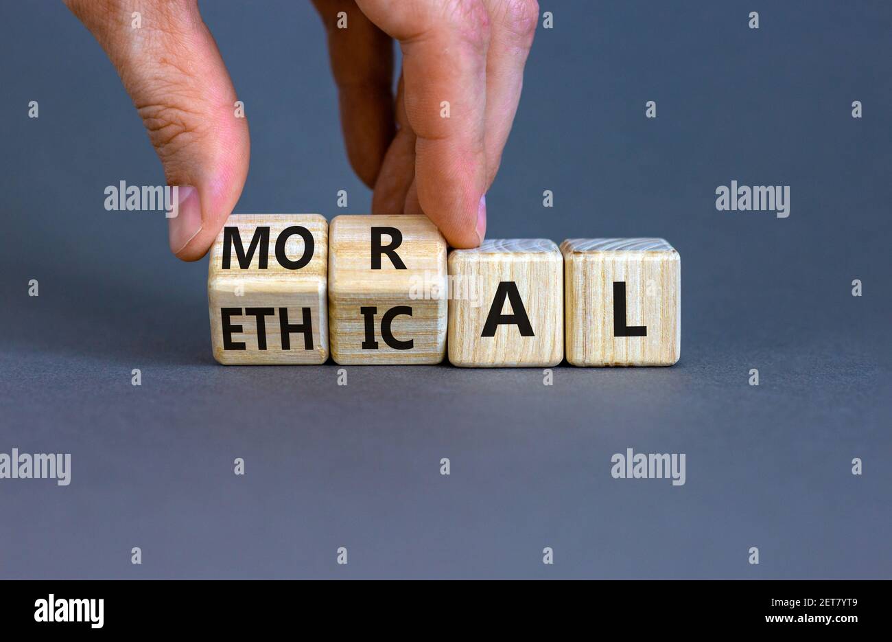 Ethical or moral symbol. Businessman turns wooden cubes and changes the ...