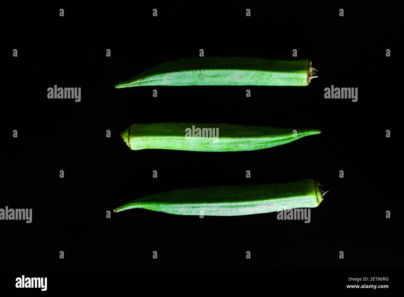 Green tropical vegetable called ladies' fingers or ochro on black ...