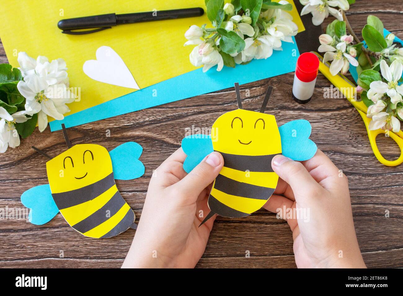 Child holding Mother's day greeting card gift - bee with spring apple ...