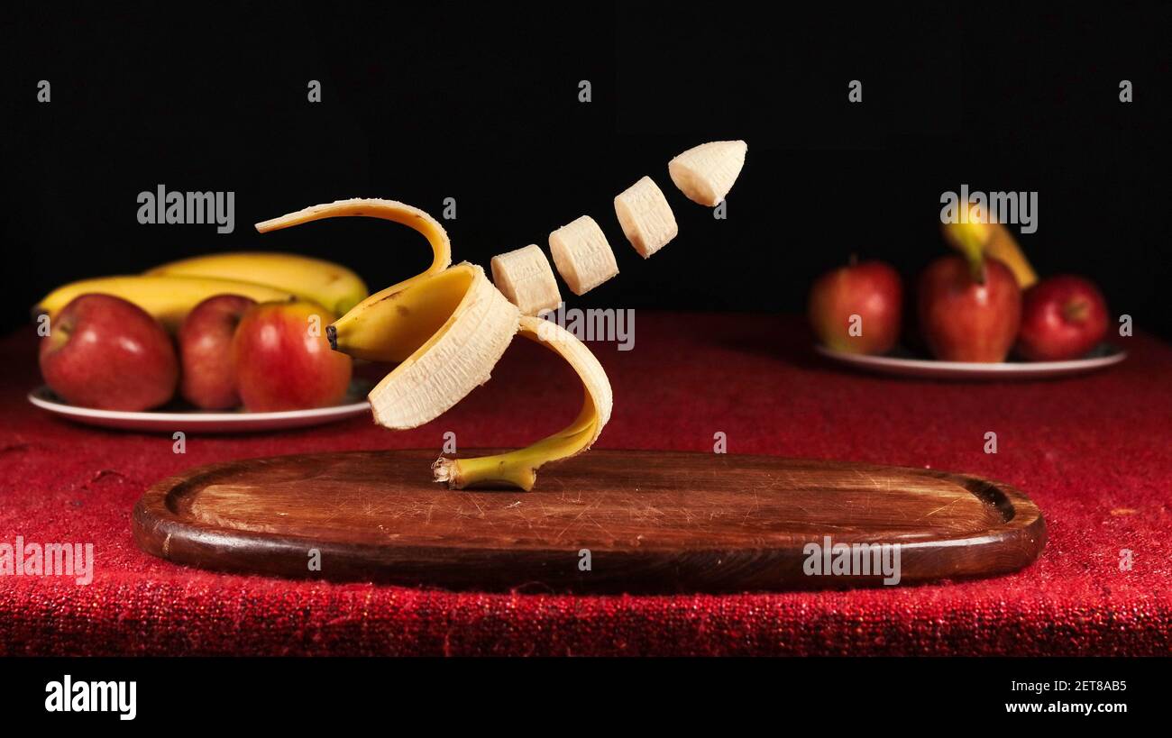 Open and sliced banana floating in the air with wooden board, in the ...