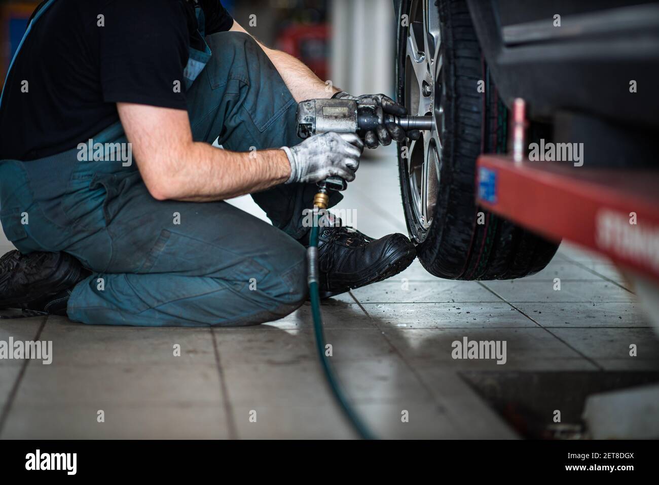 Car mechanic changing tires of a car in a repair shop,car garage ...