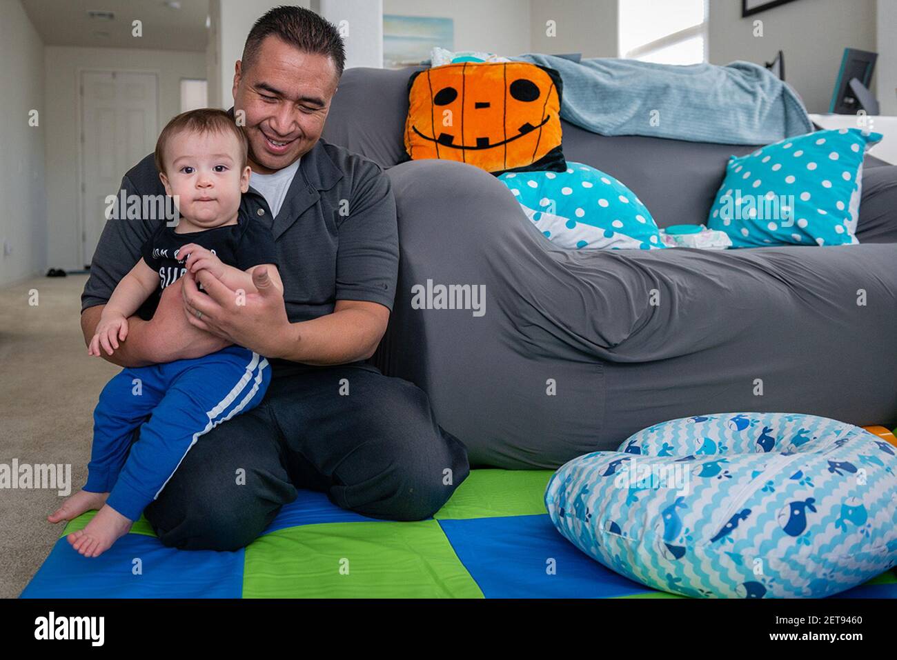 Robert Cano plays with his 10-month-old son, Brody, before leaving for work on a recent Saturday ...