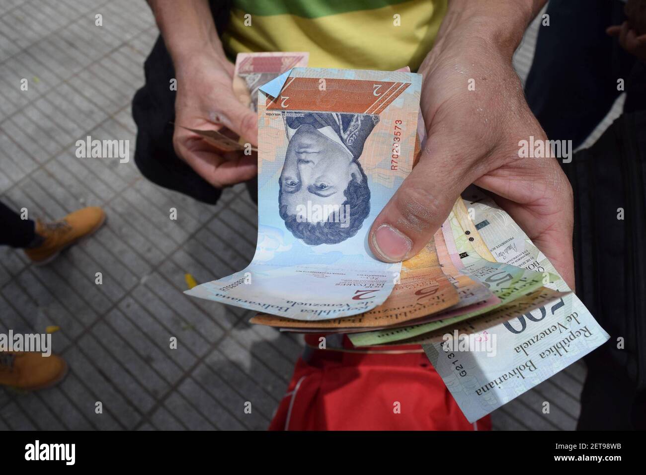 A man gives away Venezuelan bank notes in cucuta, Colombia. Venezuela's ...