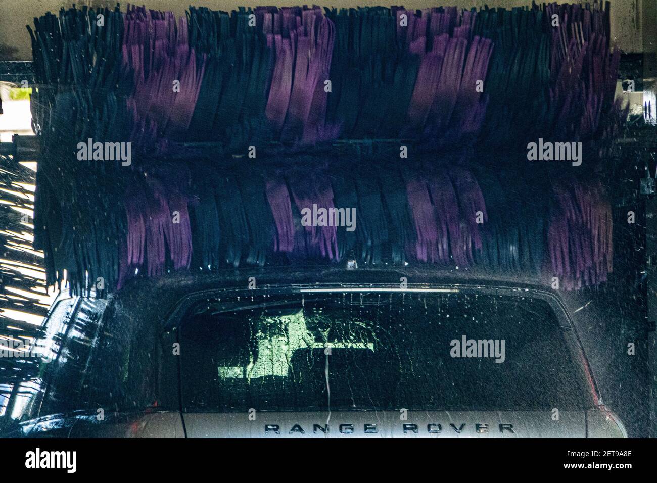 A car (silver Range Rover) being washed in an automated machine jet car ...