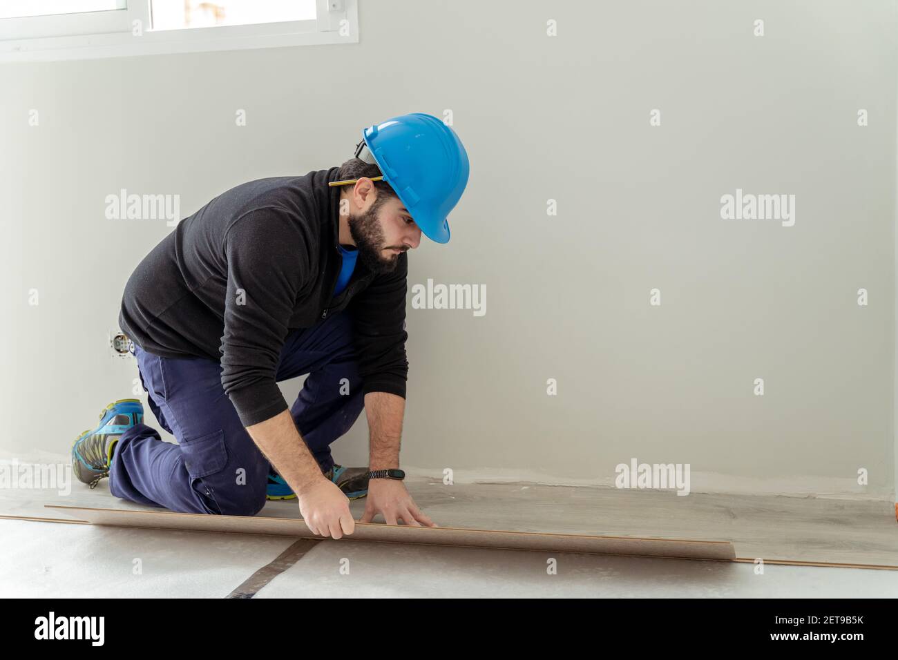 Man Carpenter assembling laminate flooring. House floor renovation ...