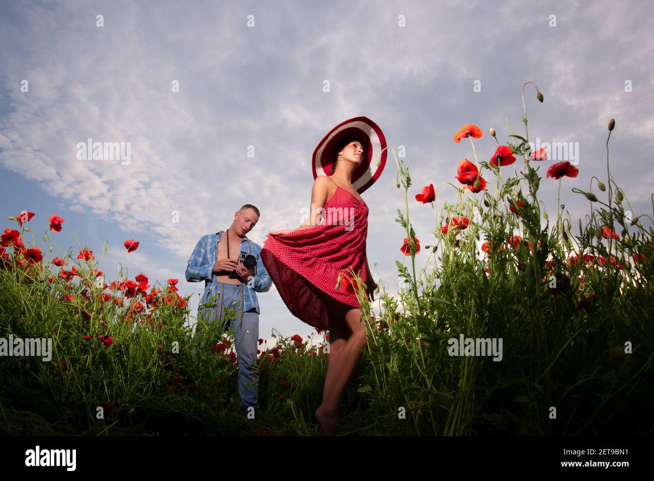 Photographer shooting lady in dress at poppy summer field. Well being ...