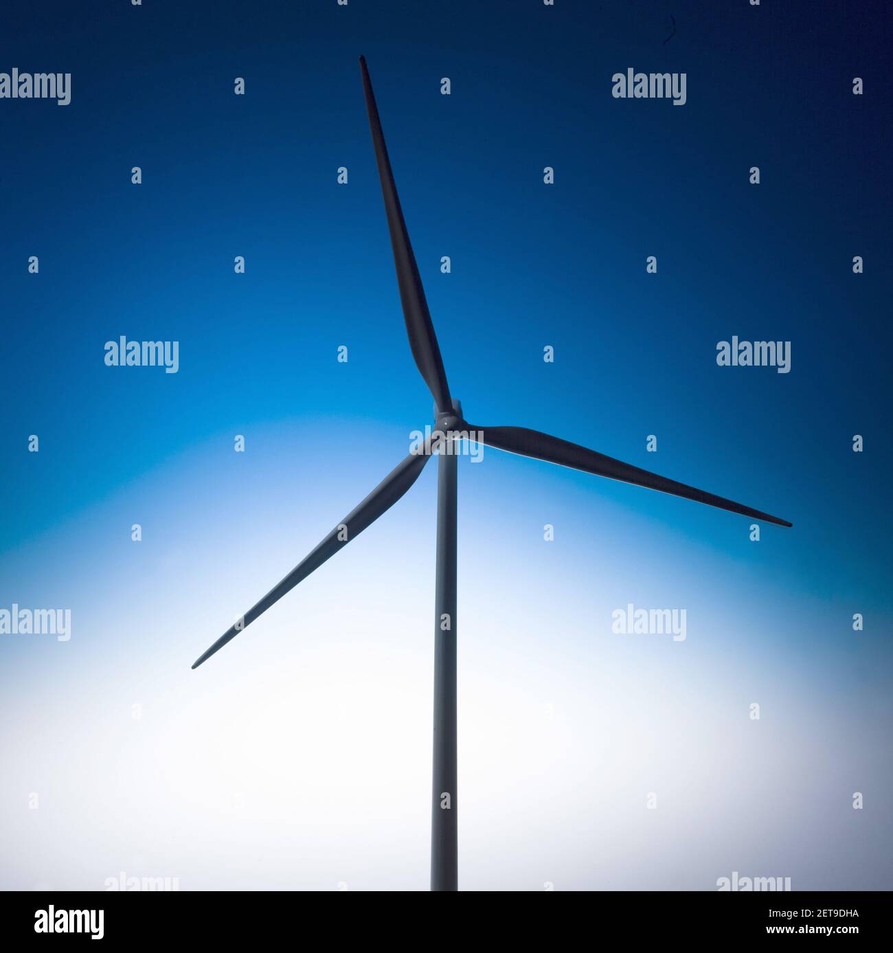 A scenic view of a miniature wind turbine against a bright blue ...