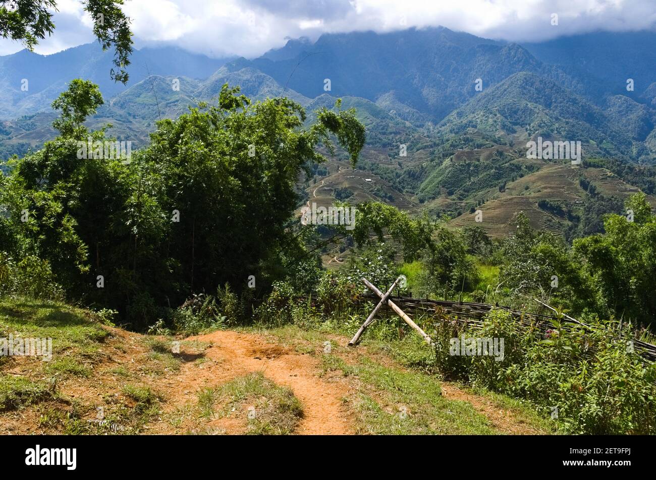 Dirt rural trail in the mountains to the village. Clouds over mountain ...
