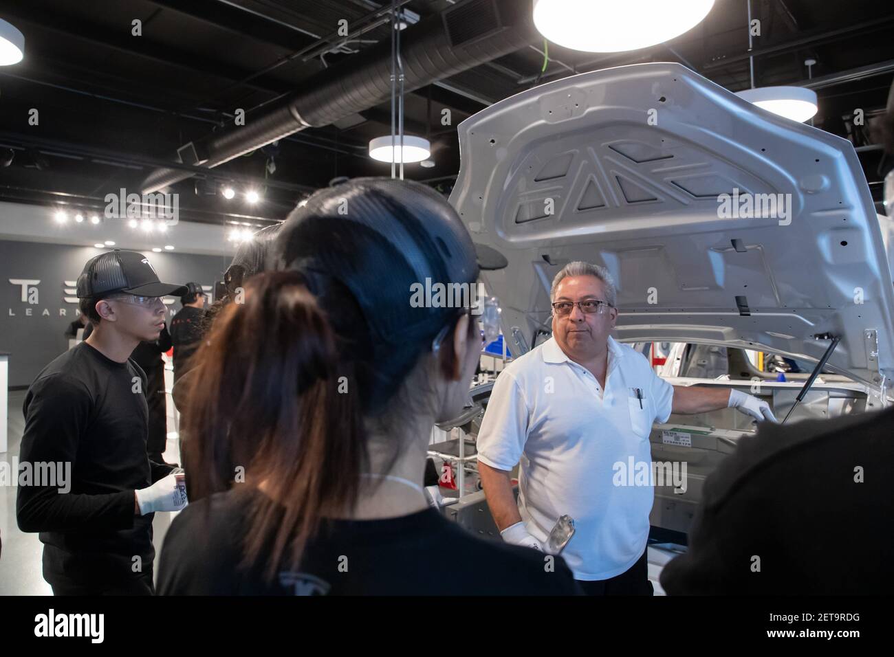 New Tesla employees are taught their task on assembling a car on March ...