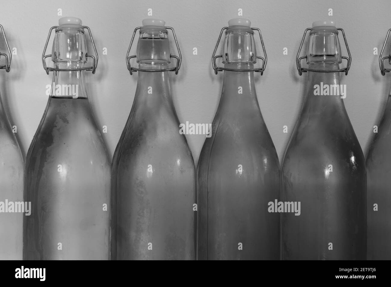Black and white photo of a row of flip top bottles of home made cider ...